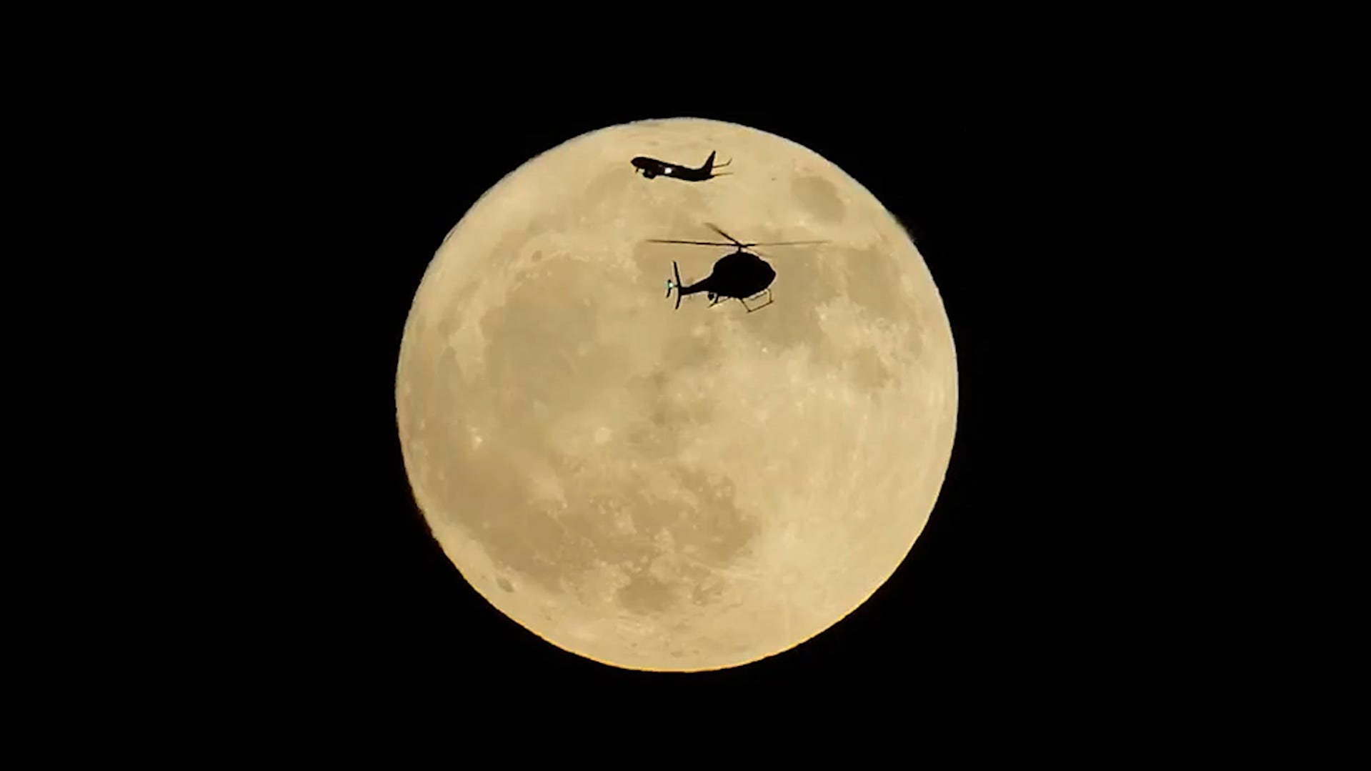 Strawberry moon creates perfect backdrop for helicopter and plane as ...