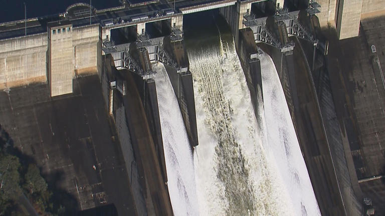 Major Sydney dam starts to spill after days of heavy rain on NSW coast