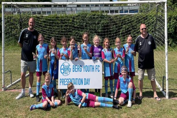 Newly formed girls' football team celebrating remarkable first season