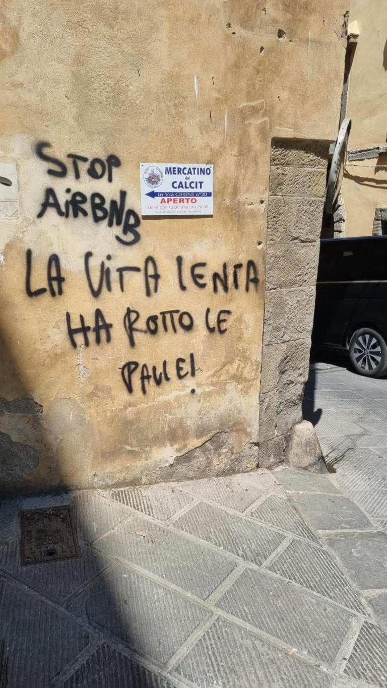 Scritte contro overtourism sui muri di Cortona