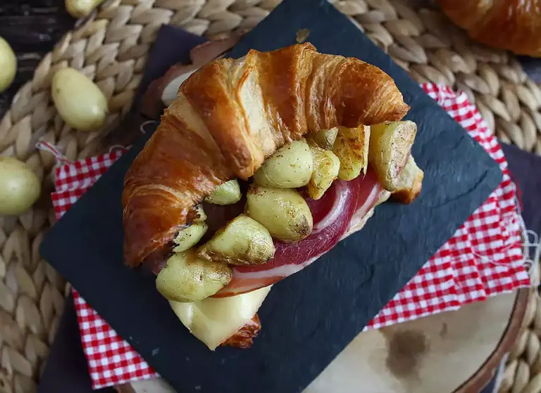 Croissant con queso raclette y patata para un brunch gourmet