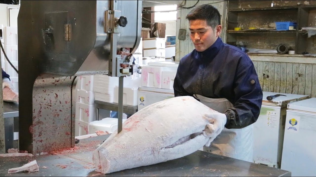 Expert Cutting of Frozen Whole Tuna at a Japanese Fish Market