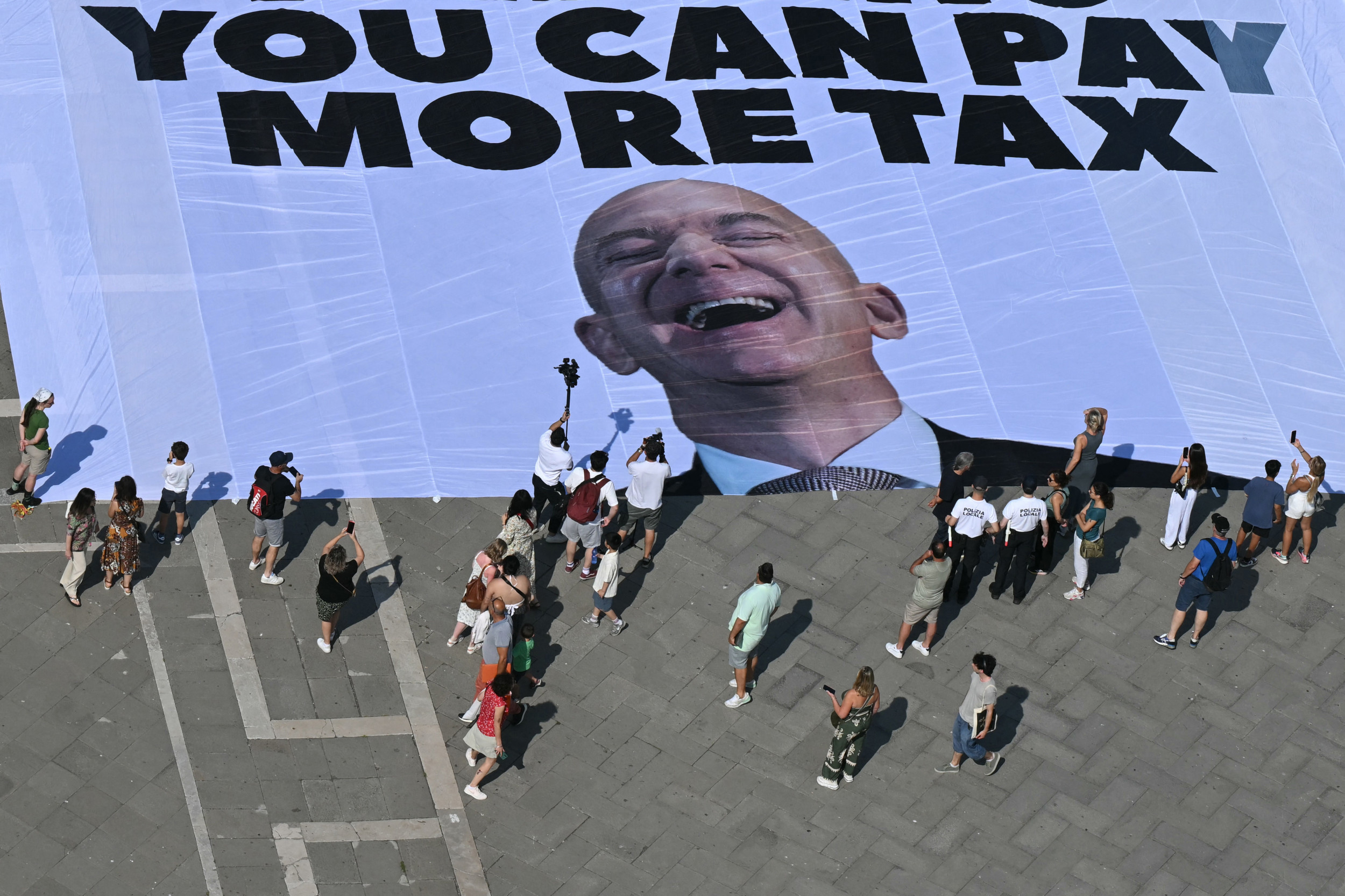 Giant banner of Jeff Bezos' face unveiled by protesters in Venice
