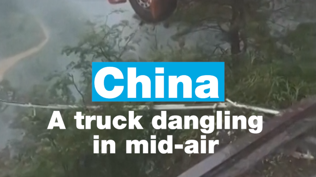 China: Truck with driver inside dangling in mid-air