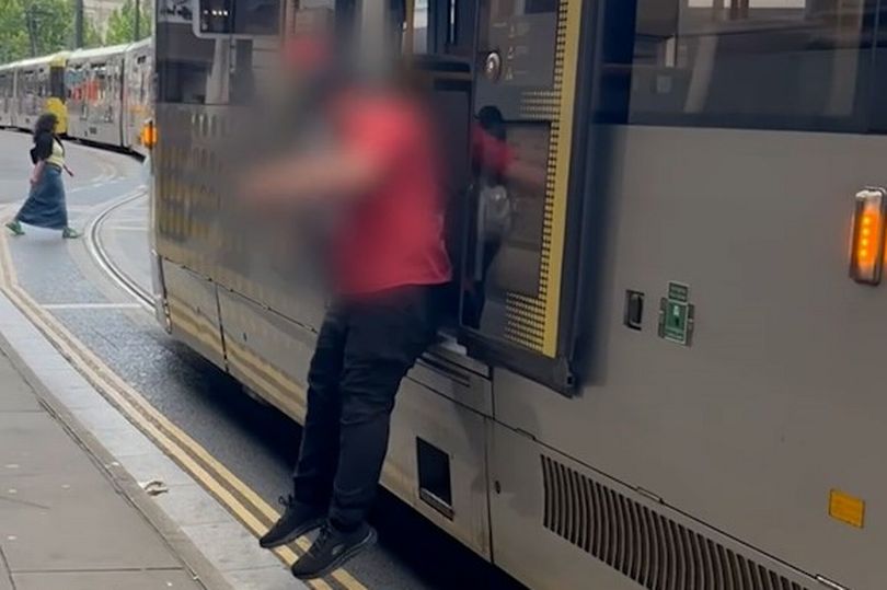 Moment people jump off trams stuck in queues in Manchester city centre