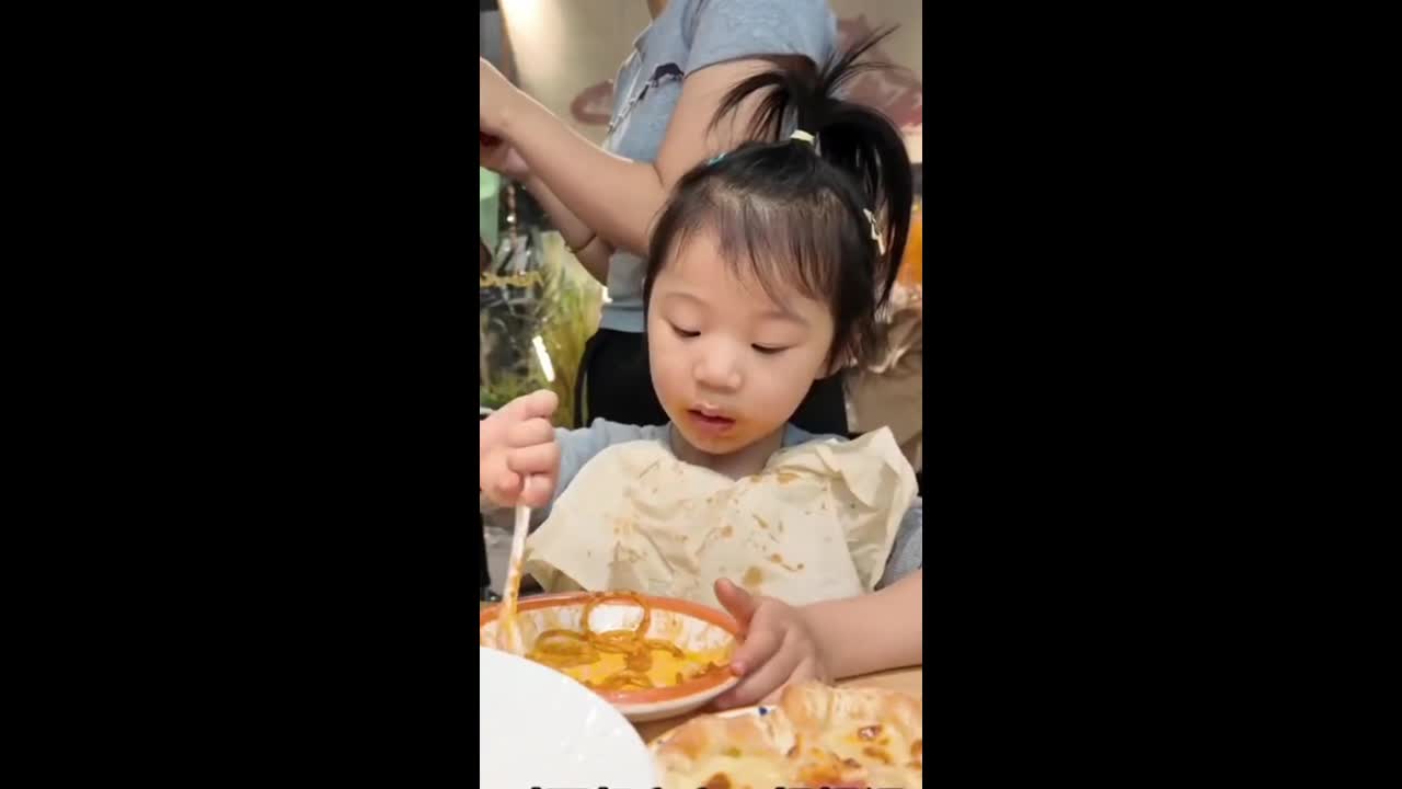 Young Chinese girl makes a mess while eating her noodles