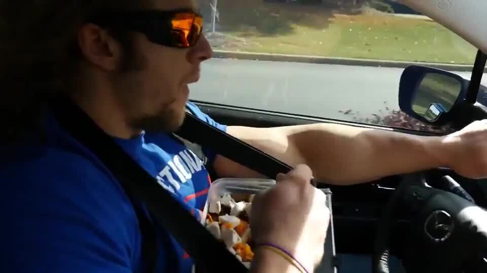 Man Demonstrates Eating Machine While Driving
