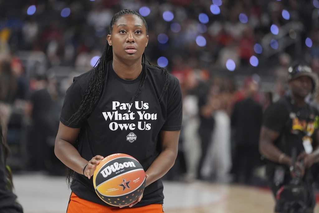 WNBA All-Stars wearing 'Pay us what you owe us' shirts