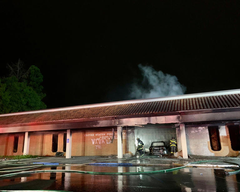 Suspect arrested after car crashes into post office and catches fire in ...