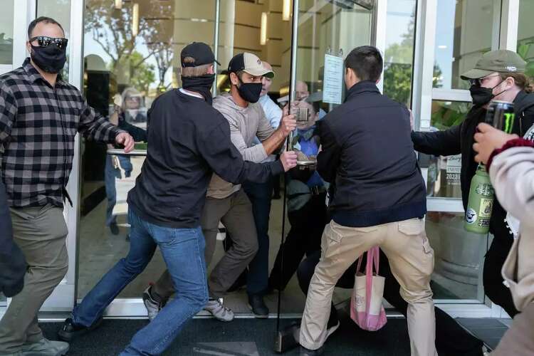 Protesters cling to departing ICE van as chaotic scene erupts outside S ...