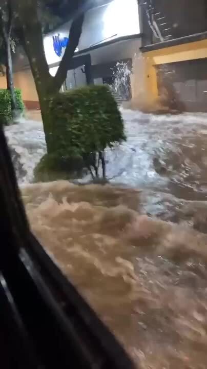 Man Standing Amidst Flood Gets Hit by Wave and Falls