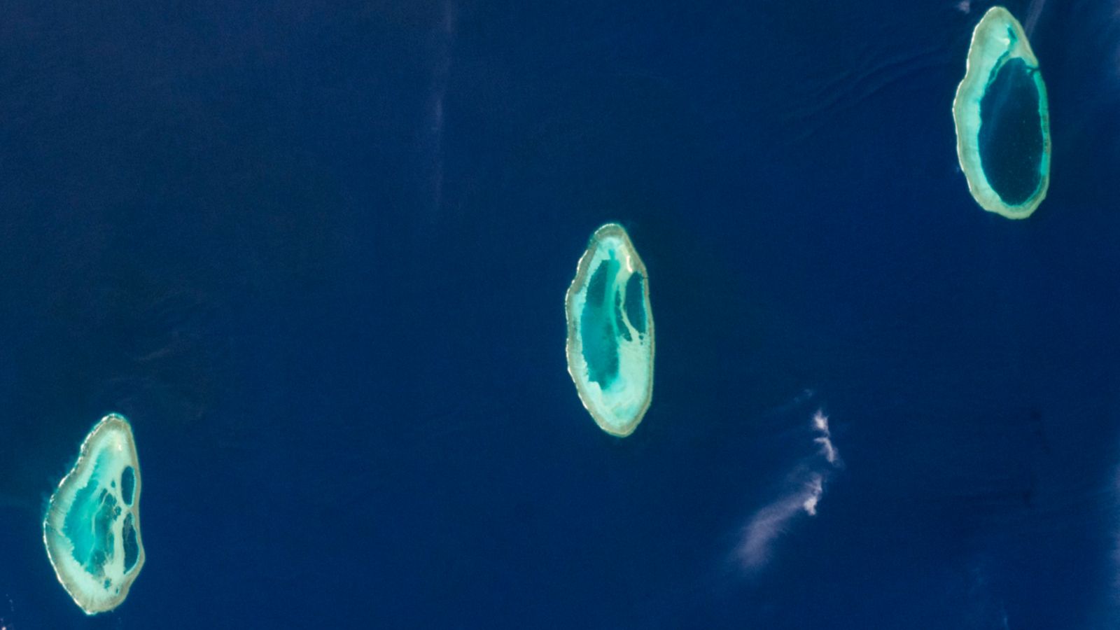 Perfect trio of prehistoric atolls shine like tropical gems off ...