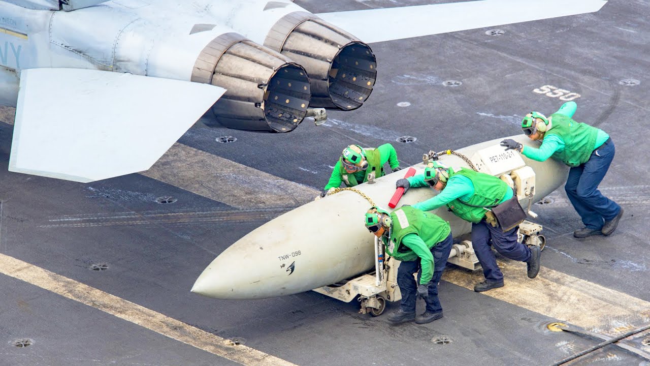Installation of large F-18 fuel tanks on US aircraft carrier during ...