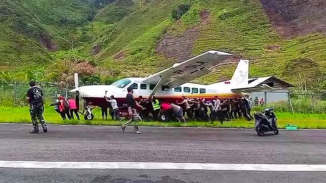 Indonesian airport crew push plane off runway after tire blowout