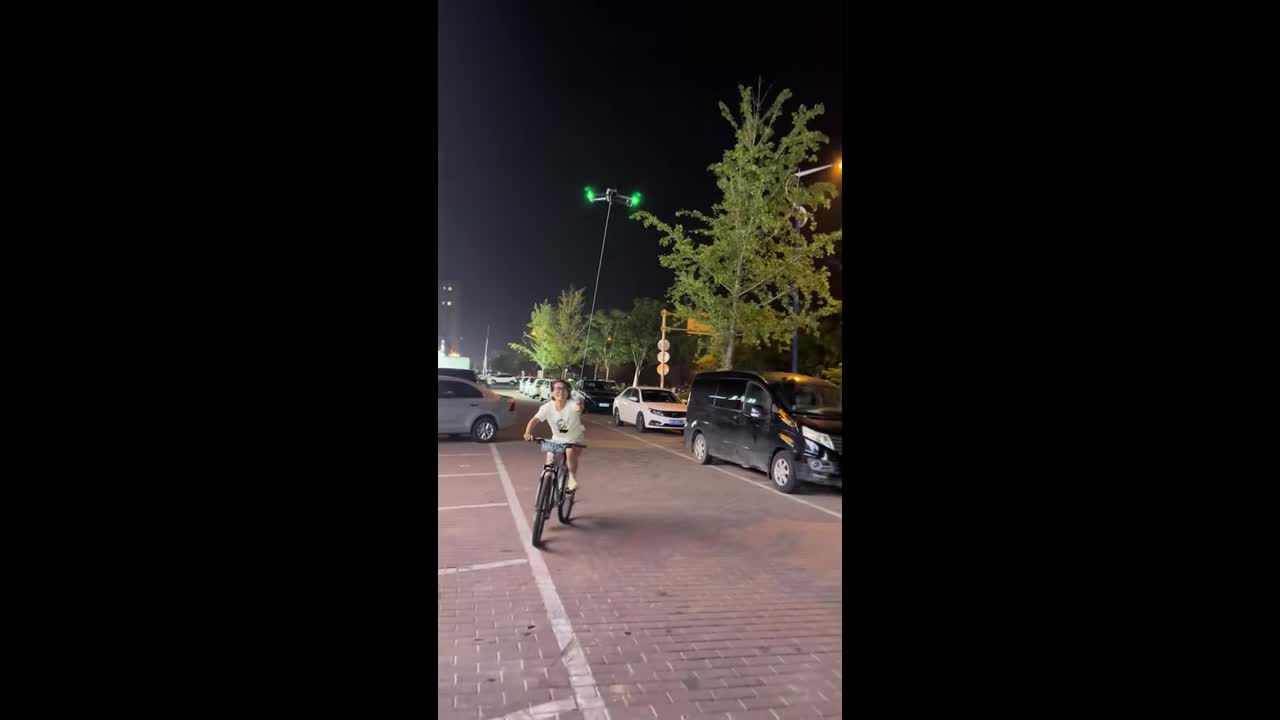 Woman on bicycle pulled by drone in Shandong, China