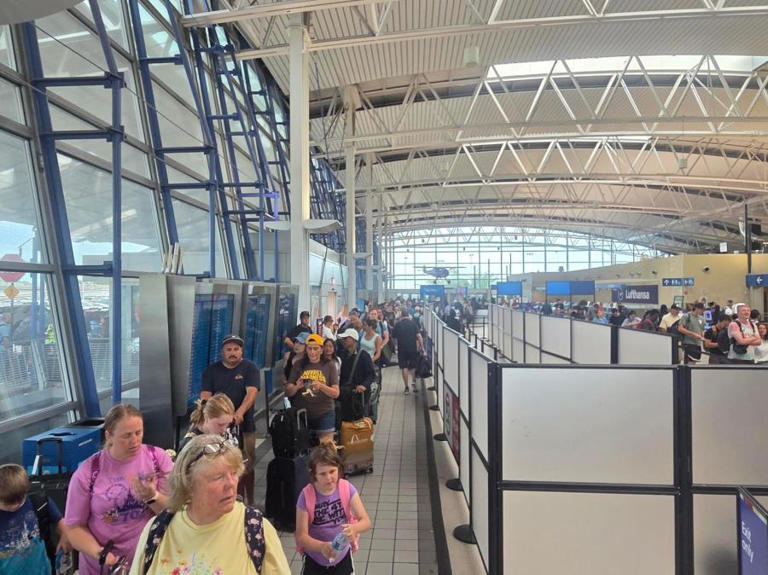 Lines extend outside Lambert Airport terminal as large St. Louis ...