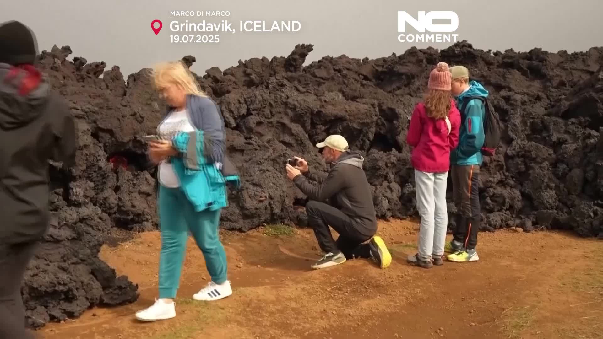 Touristen beobachten sprühende Lava beim Vulkan auf Island
