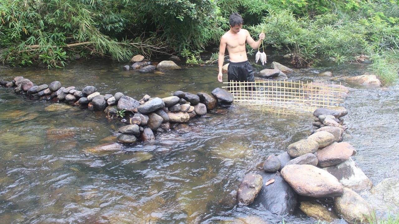 Primitive Technology: Build a stone dam to trap fish and cook fish in ...