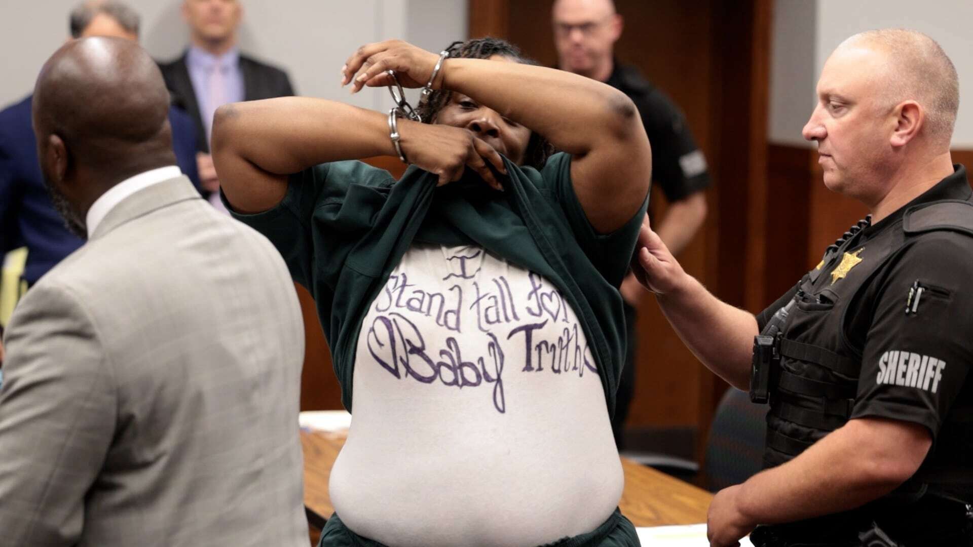 Woman accused of murder of foster family reveals message on T-shirt ...