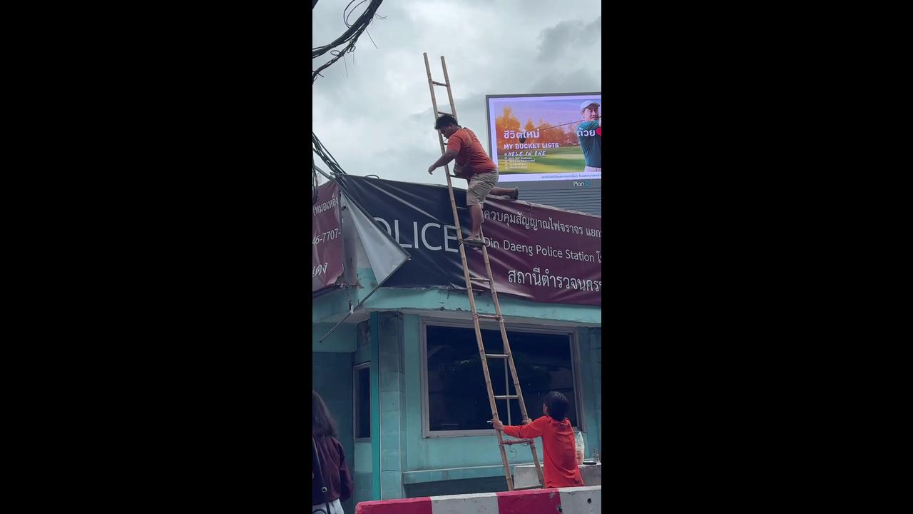 Workers repair police booth roof in their flip-flops