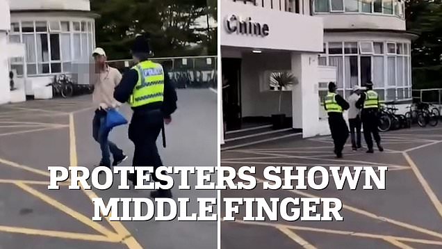 Moment asylum seeker gives middle finger to protestors