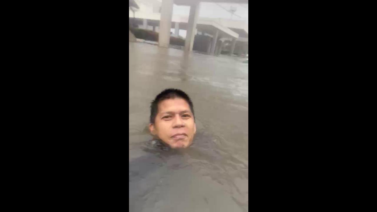 Driver battles to save stranded car as floods swamp the Philippines