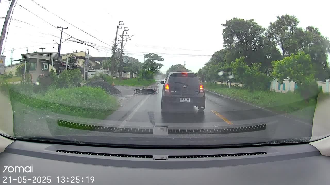 Motorists help elderly woman who falls from motorcycle on wet road