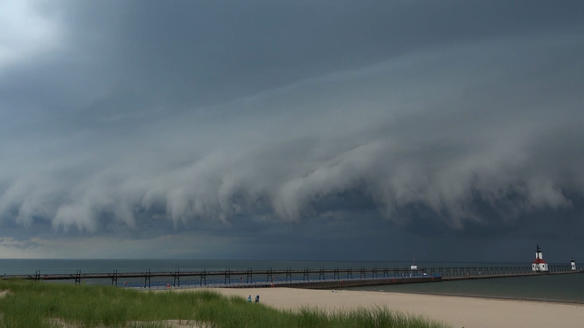 Timelapse: Massive shelf cloud rolls over Lake Michigan beach town
