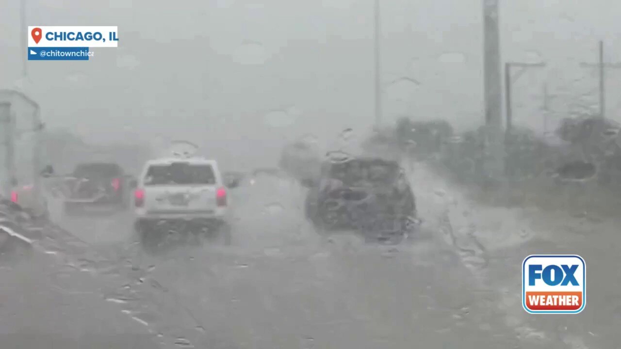 Cars drive through flooding on Interstate 55 in Chicago