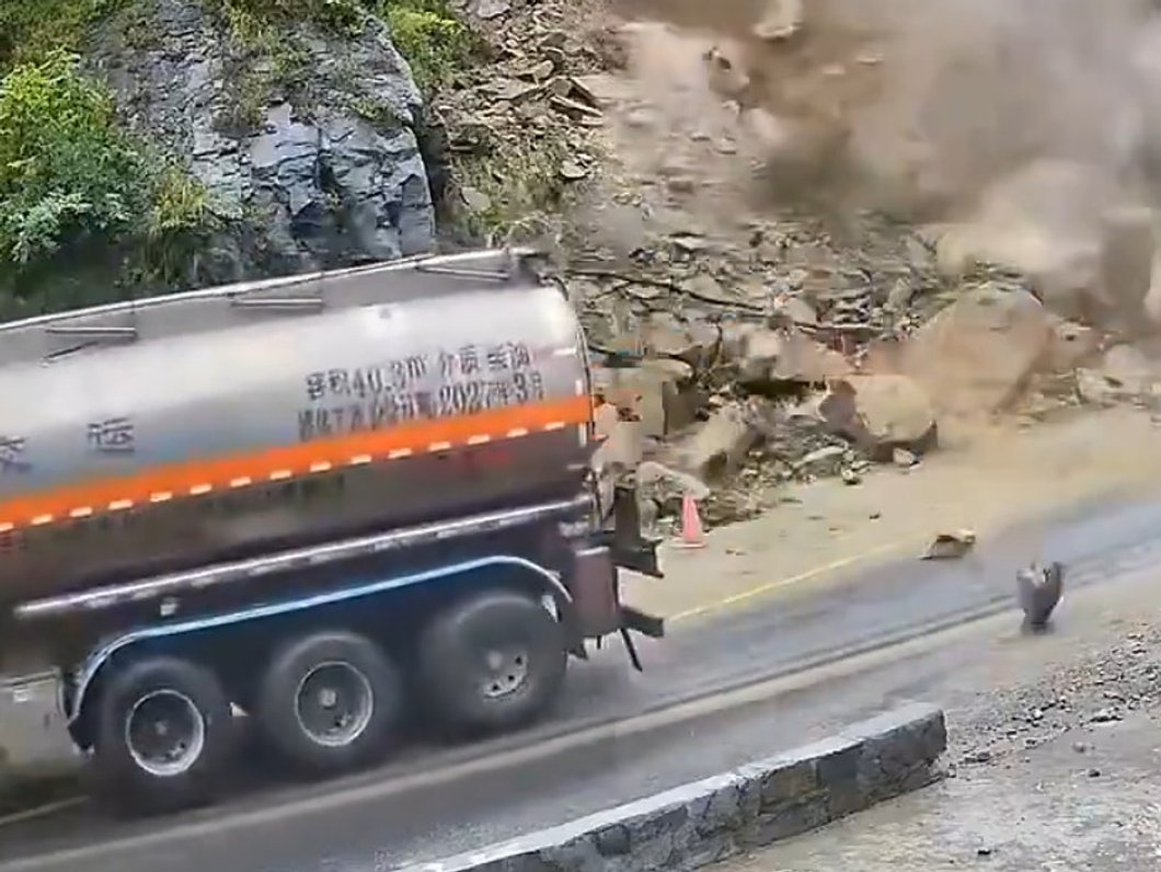 Rockslide on road: tanker truck drives through anyway