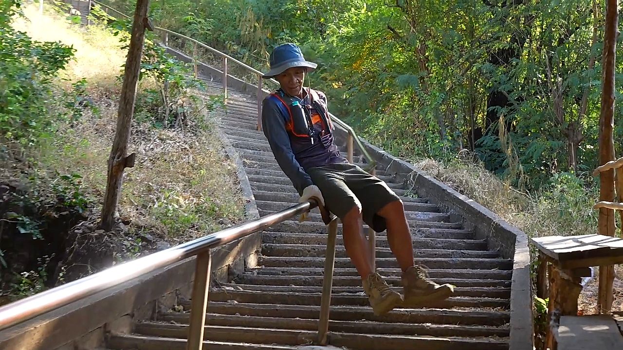 Thailand temple staff slide on handrail to go down steep 3,790-step ...