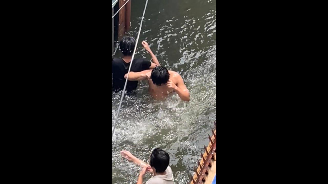Children teach their friend to swim while streets are flooded
