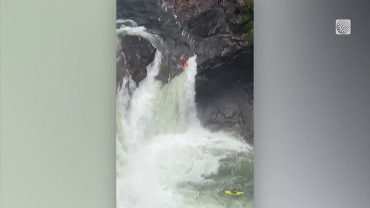 Two kayakers ride over a waterfall in Wells Gray Provincial Park in ...