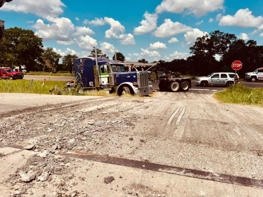 18-wheeler causes train backup, hits vehicle, falls in ditch