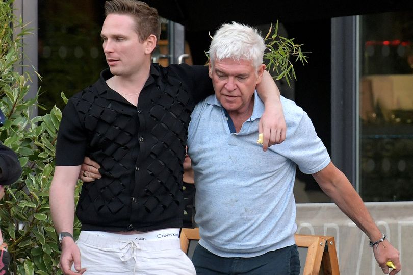Phillip Schofield clings onto male companion as he leaves bar after ...