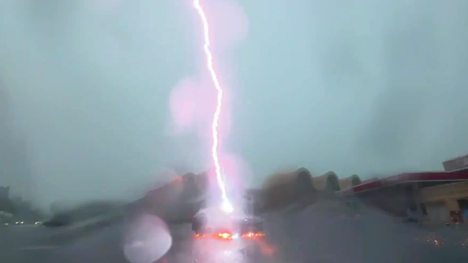 Dramatic moment lightning bolt strikes moving car - sending sparks flying