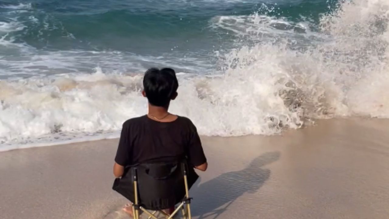 Boy gets knocked over by a wave while trying to film a video