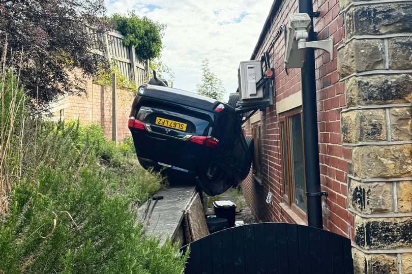 Runaway car flips upside down and crashes into gym window