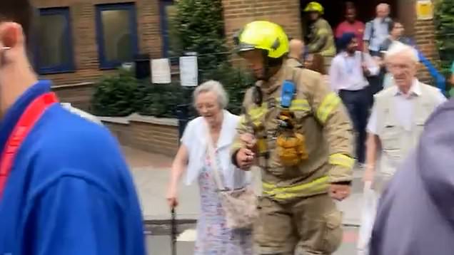 Fireman assists elderly patient as Guys hospital evacuated due to ...