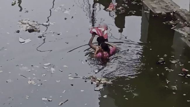Man Carries Baby Through Floodwater as Severe Rain Hits India