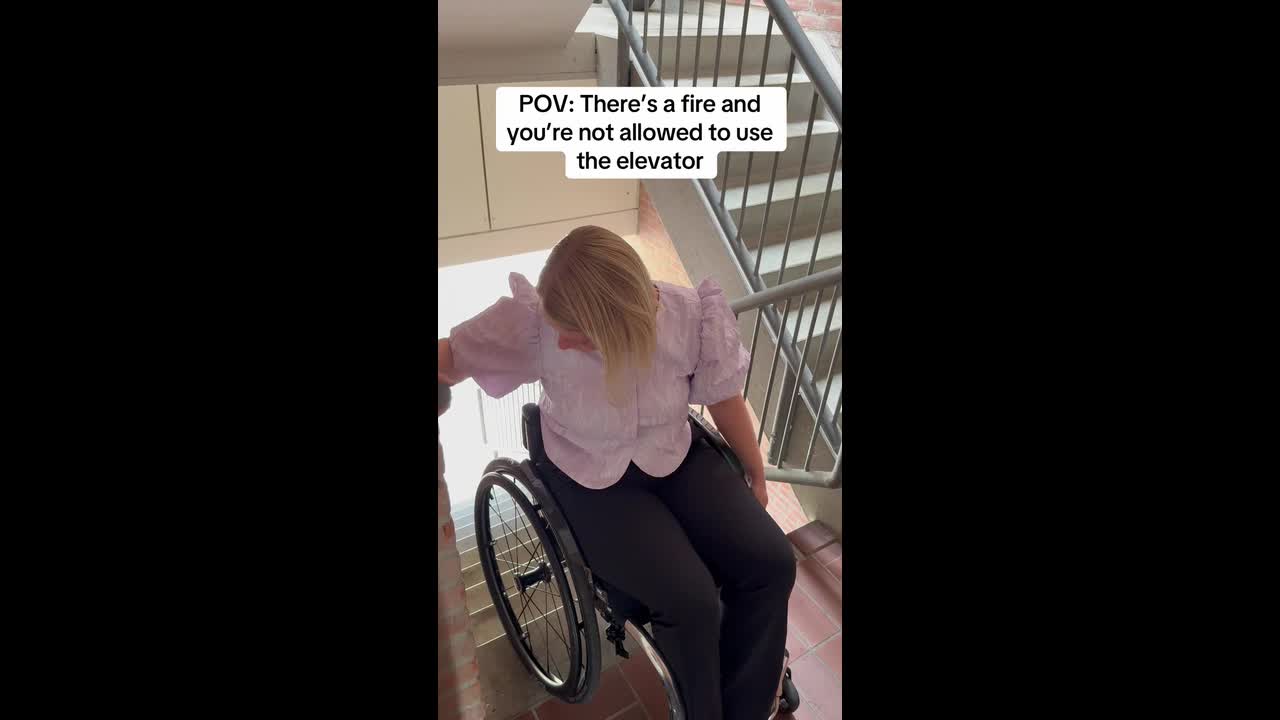 Wheelchair user demonstrates stair descent during fire emergency amid ...