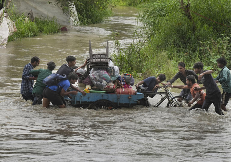 Cots float, families wade through water as Yamuna rises in Delhi