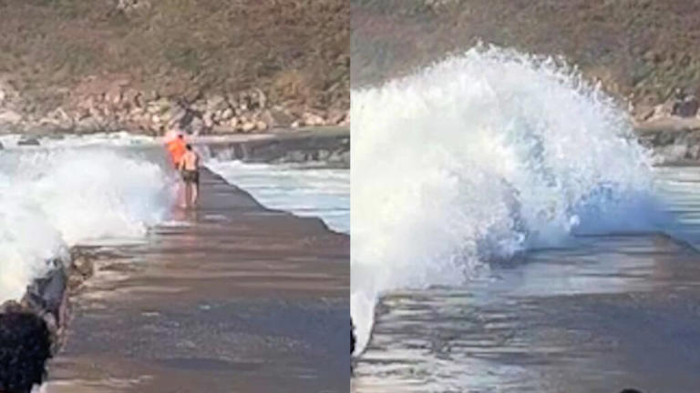 Dramatic moment two people swept away by crashing waves