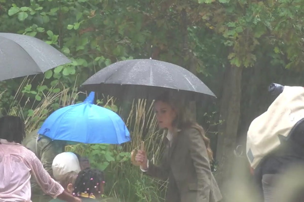 Sweet moment Kate shields schoolchildren during rain as she debuts ...