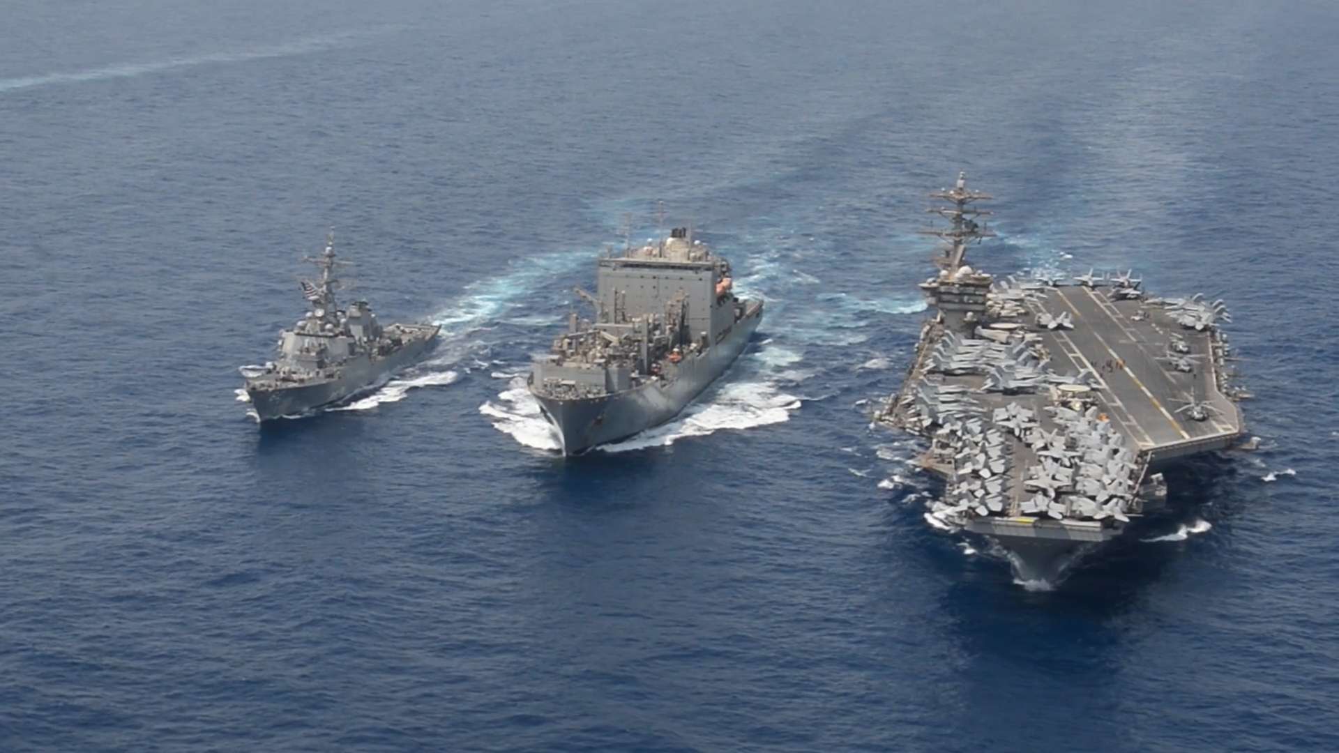 Helikopterbeeld: Amerikaanse marine verplaatst vracht tussen schepen