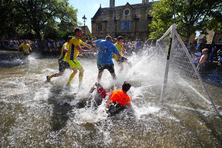 Traditional river football match goes ahead despite waterlogged pitch