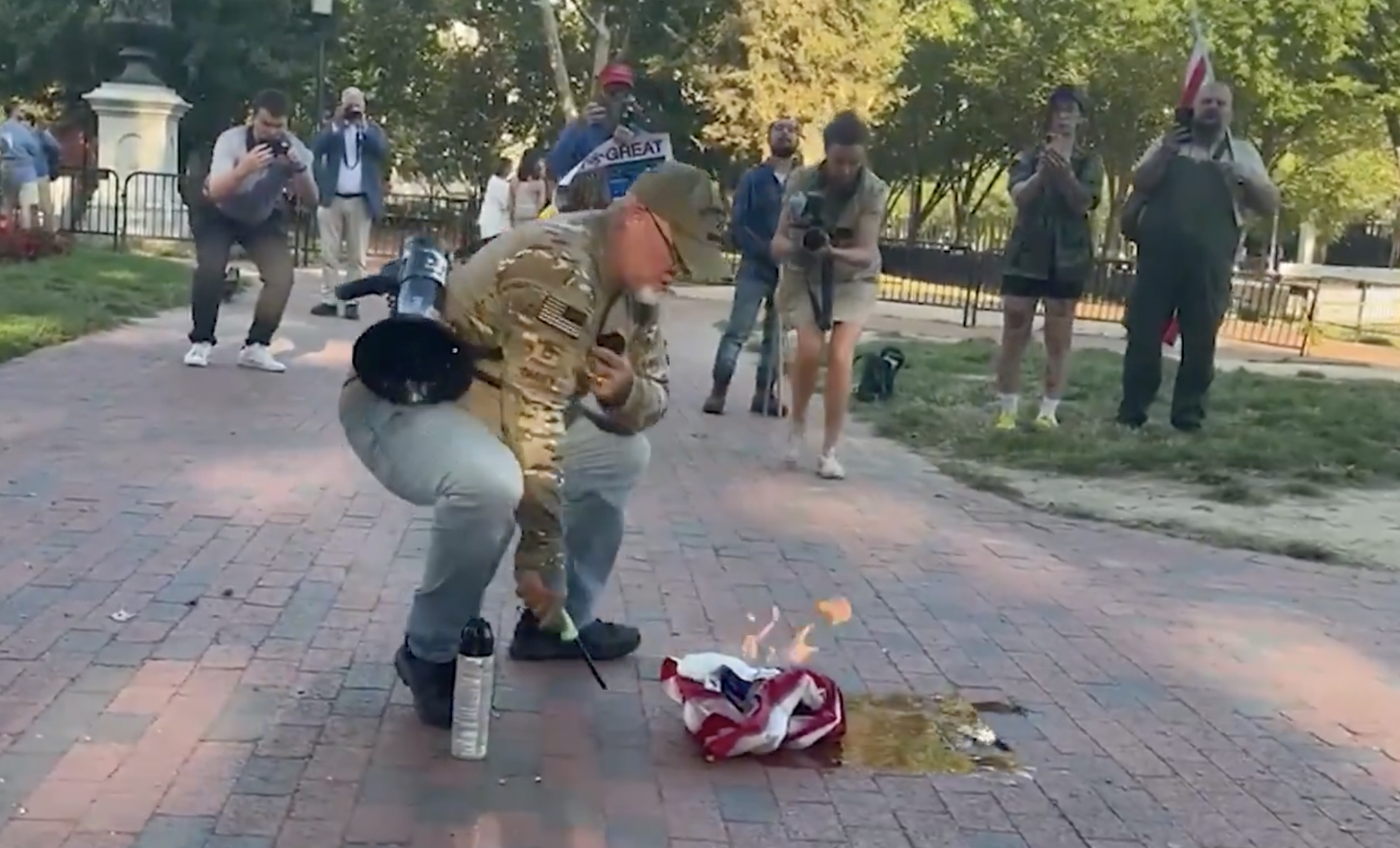 Veteraan die Amerikaanse vlag als protest tegen Trump in brand steekt ...