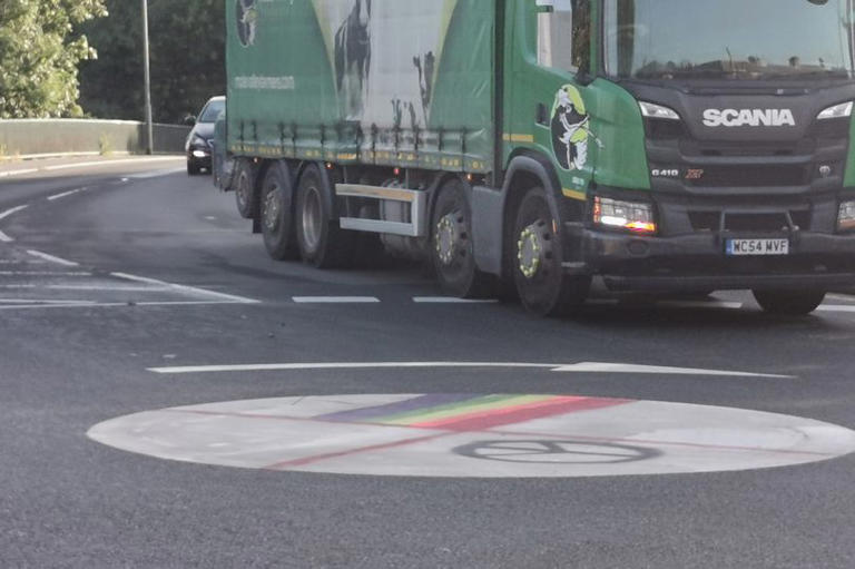Flag on Devon roundabout updated with rainbow and peace symbol