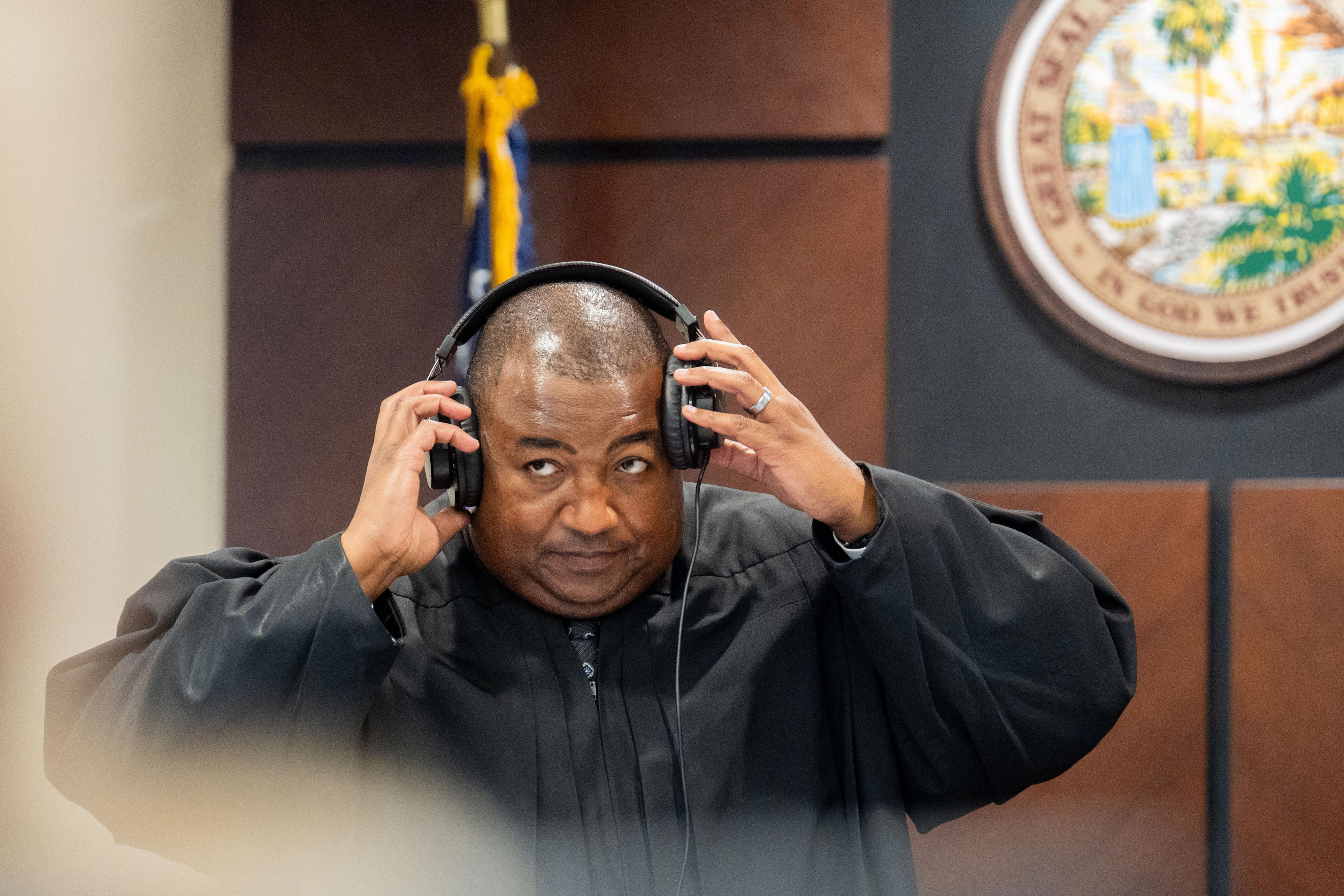 Why is Donna Adelson wearing headphones during the Dan Markel murder trial?