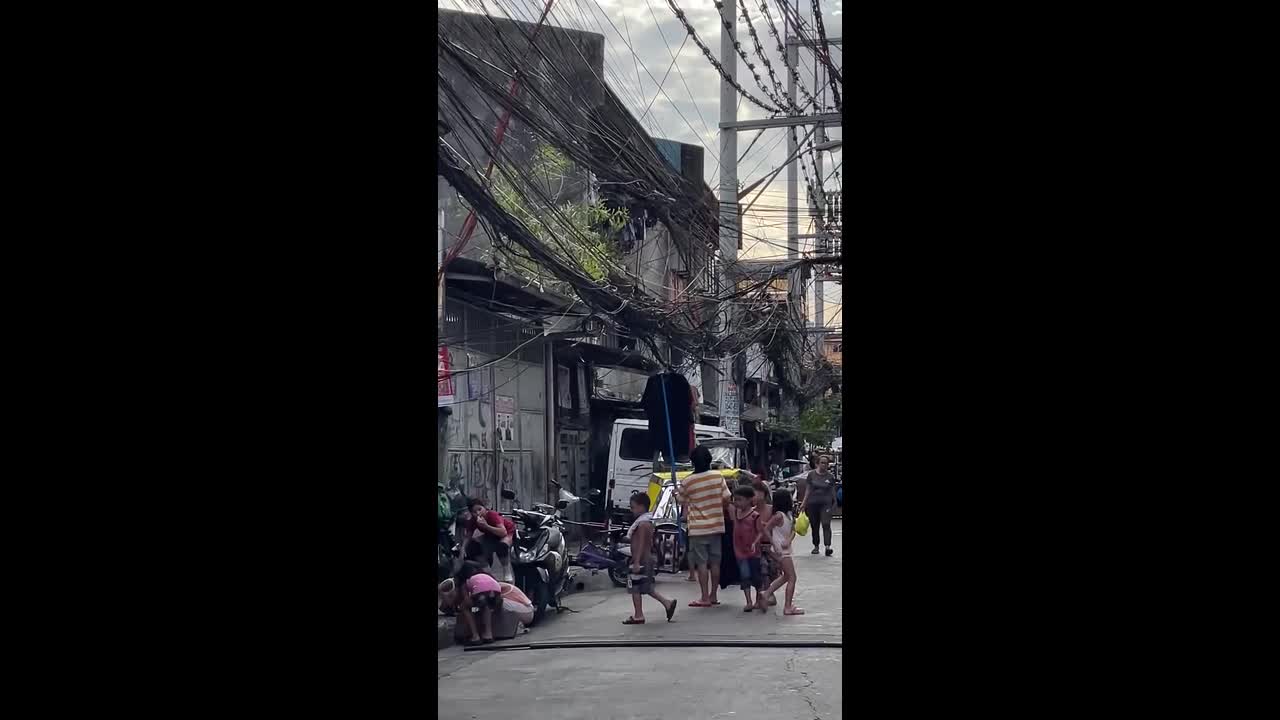 Manila slum residents hang their clothes out to dry on city's phone lines